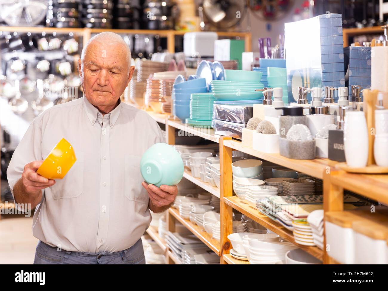 Mature man choosing new dishes at store Stock Photo - Alamy
