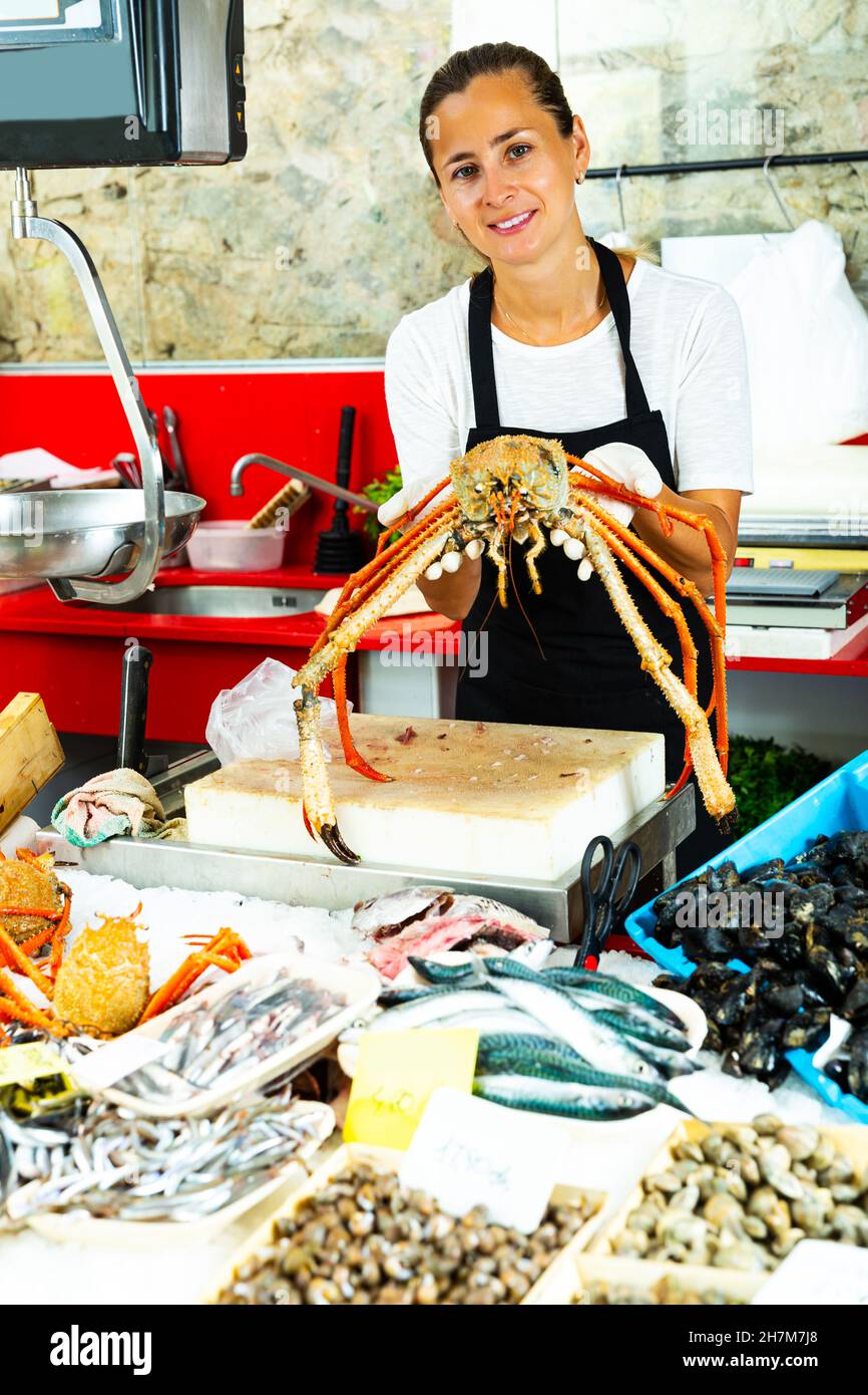 fishmonger offering fresh spiny spider crab for sale Stock Photo - Alamy