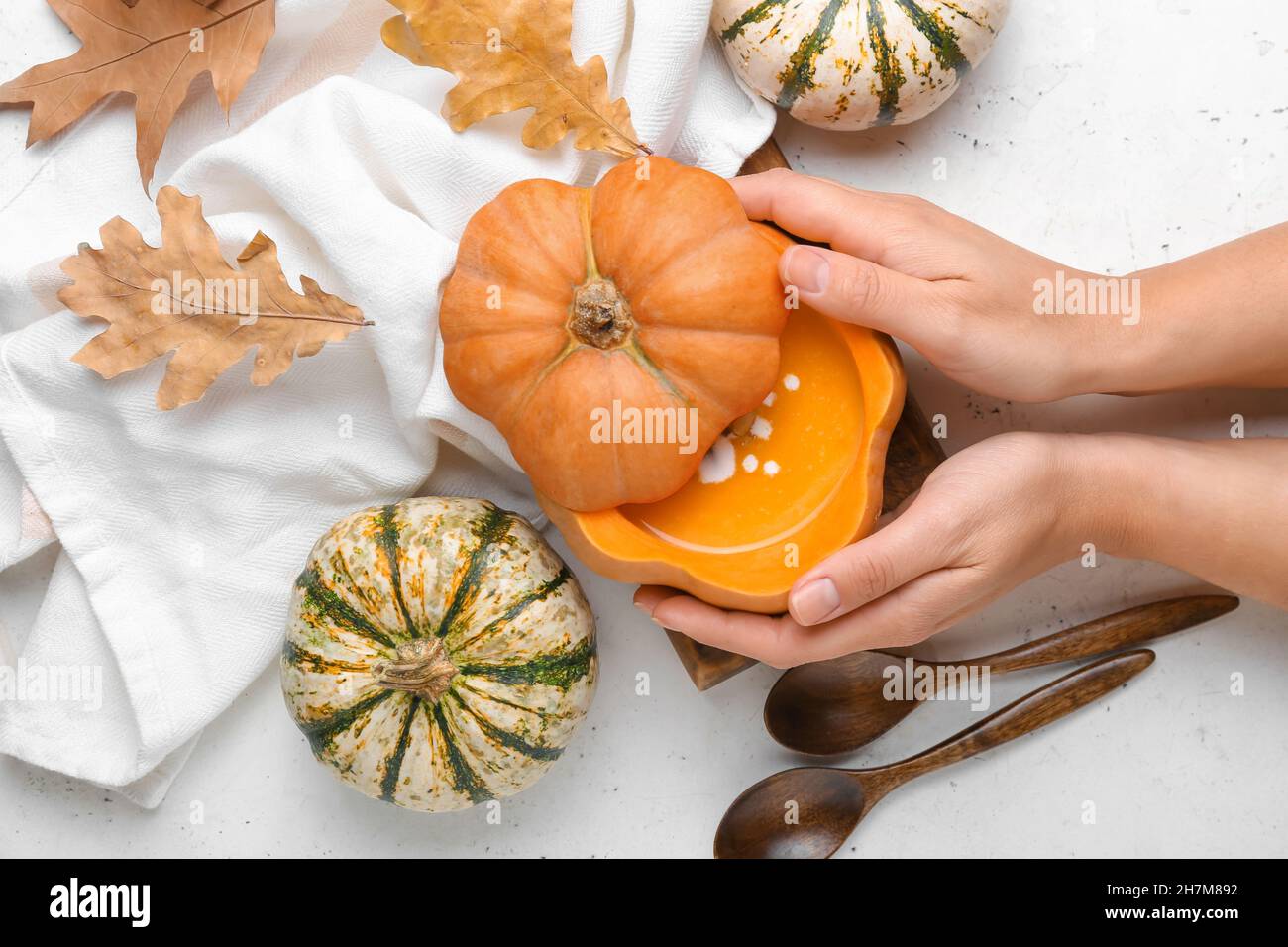 Female hands with tasty soup served in pumpkin on white background ...