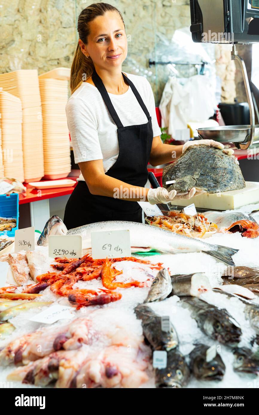fishmonger demonstrating fresh flounder Stock Photo - Alamy