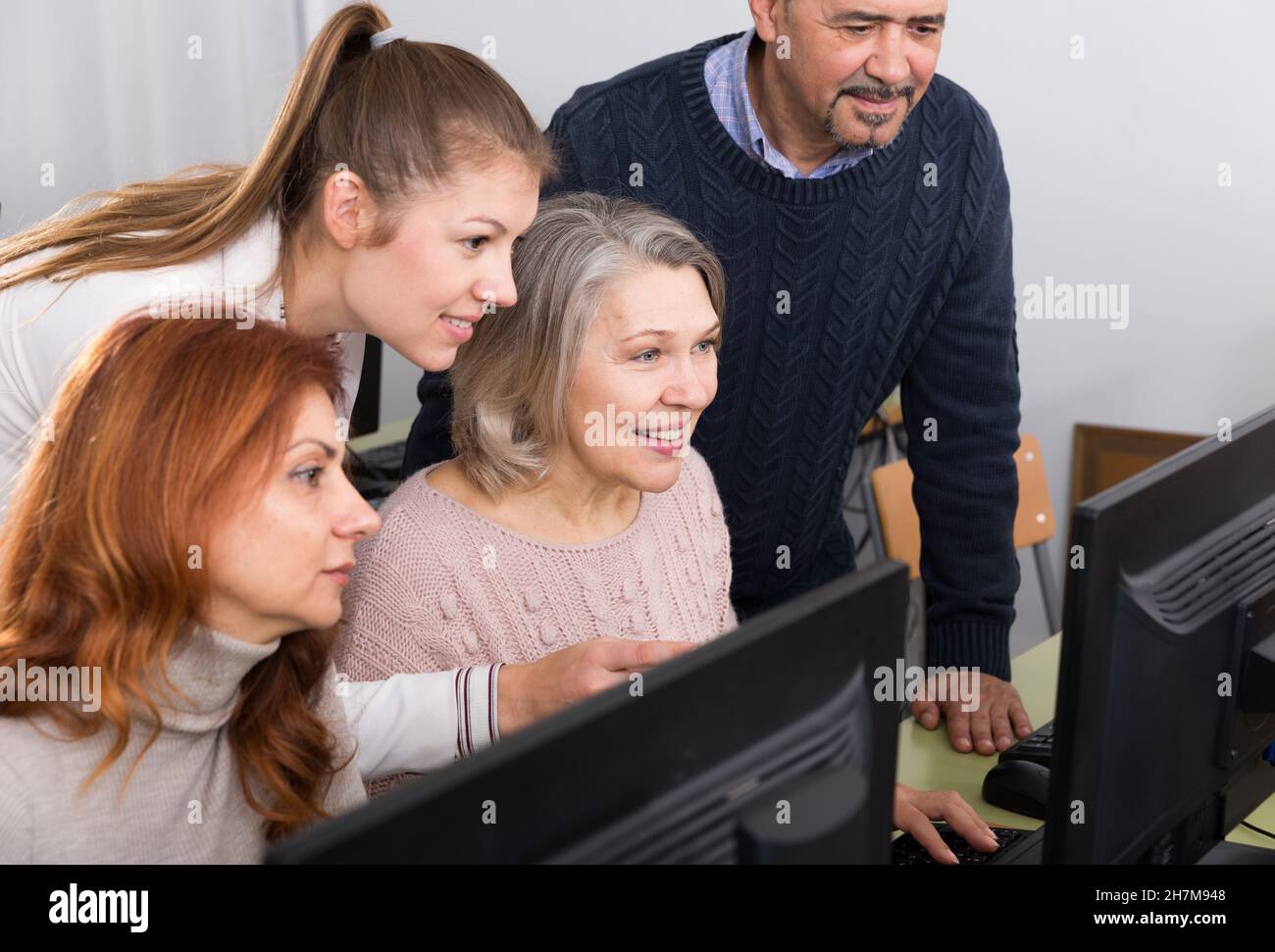 Business people grouped around laptop hi-res stock photography and ...
