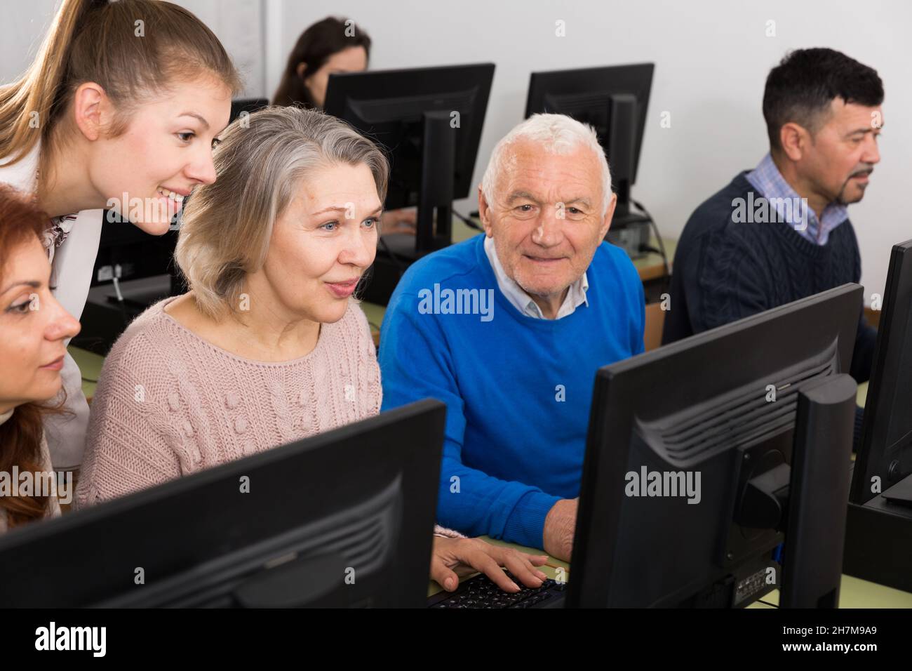 Students of different ages looking at monitor Stock Photo - Alamy