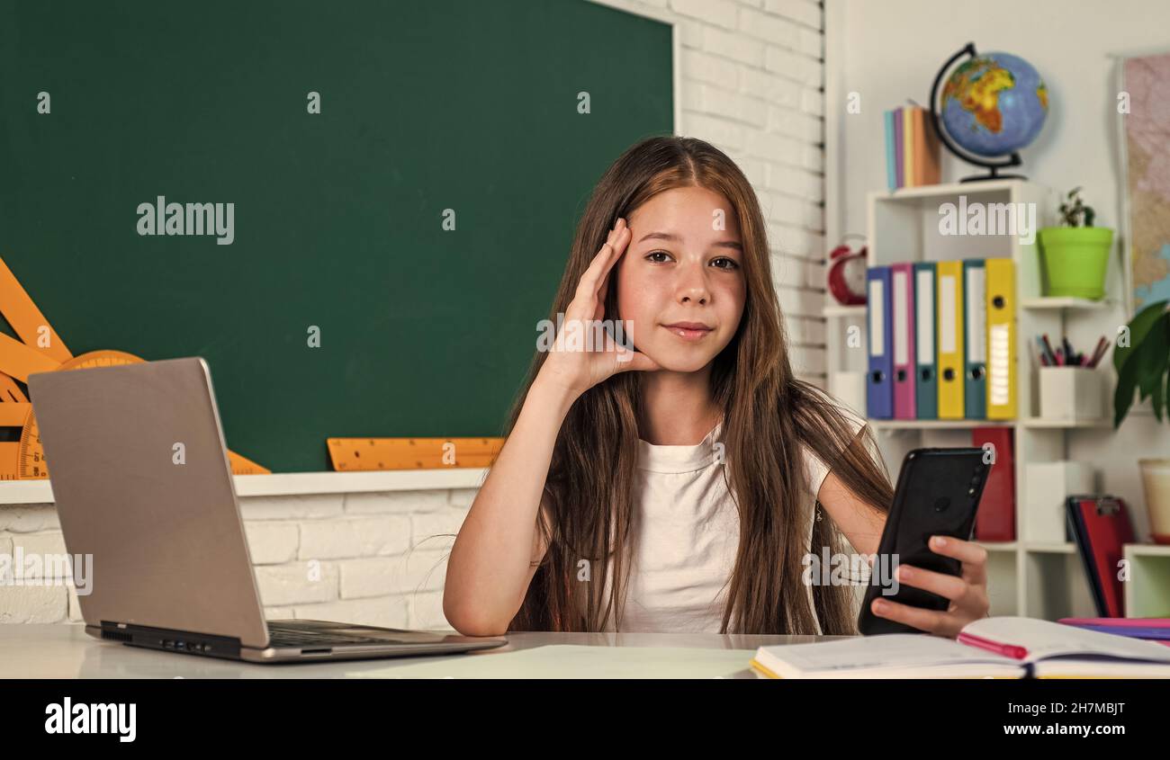 child pupil sit at table and use computer. girl is college student ...