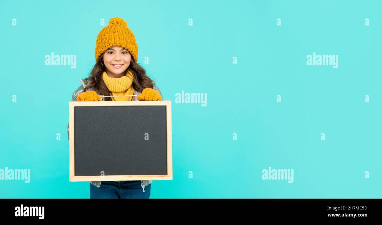 happy kid in hat hold school blackboard with copy space on blue ...