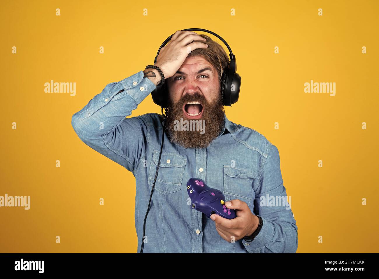 oh no. console controller joystick. gaming in earphones. mature man ...