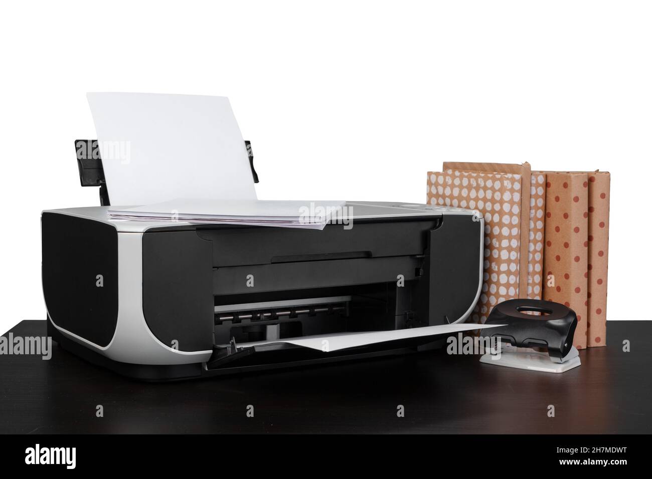 Printer and stack of books on black table against white background ...