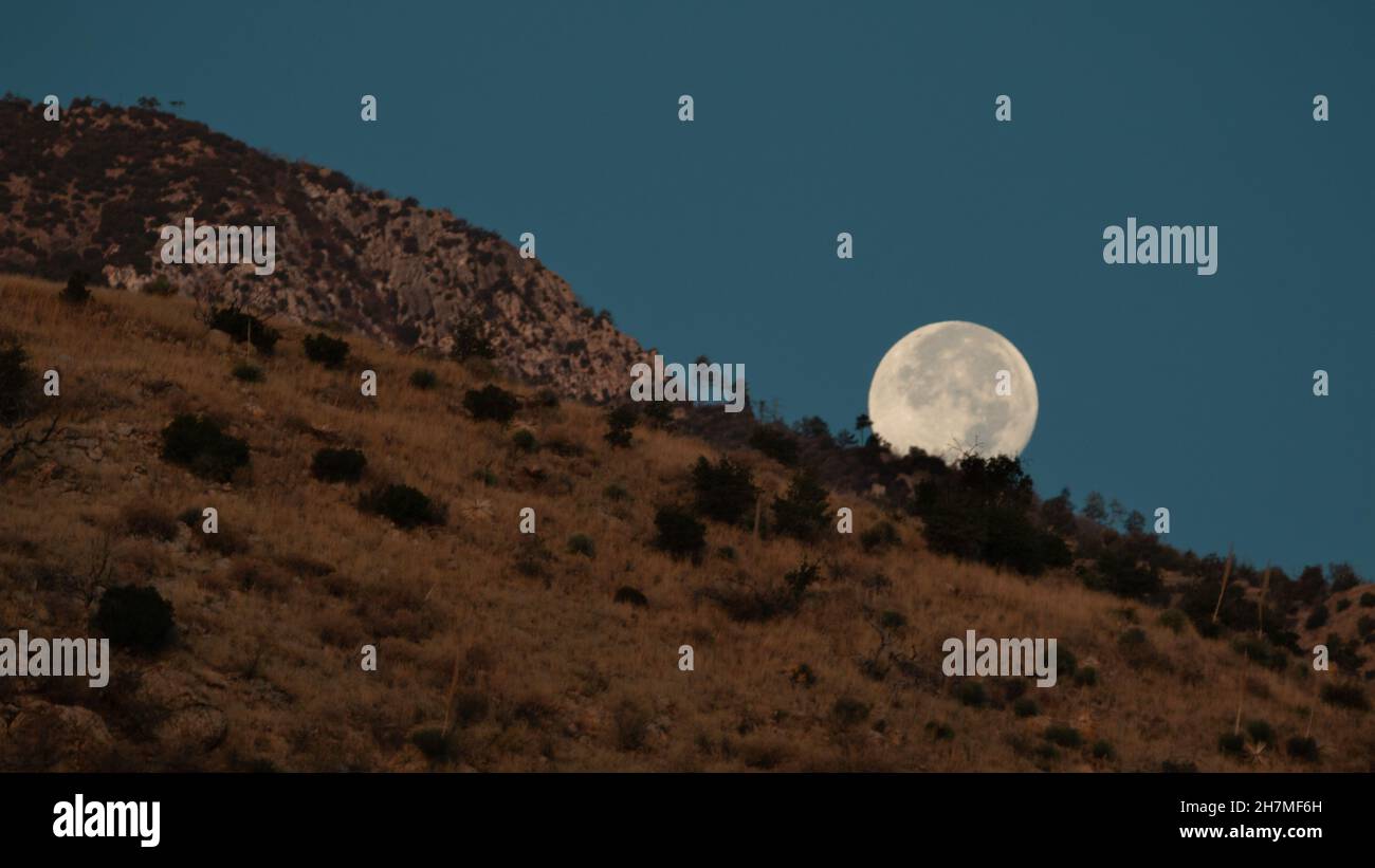 Large Moon on the Mountain Horizon Stock Photo - Alamy