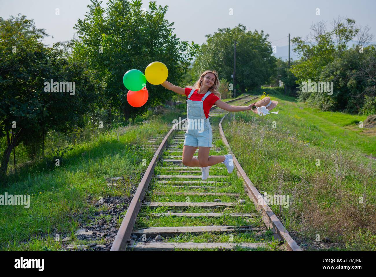 beautiful girl jumping with balls on the railroad Stock Photo - Alamy