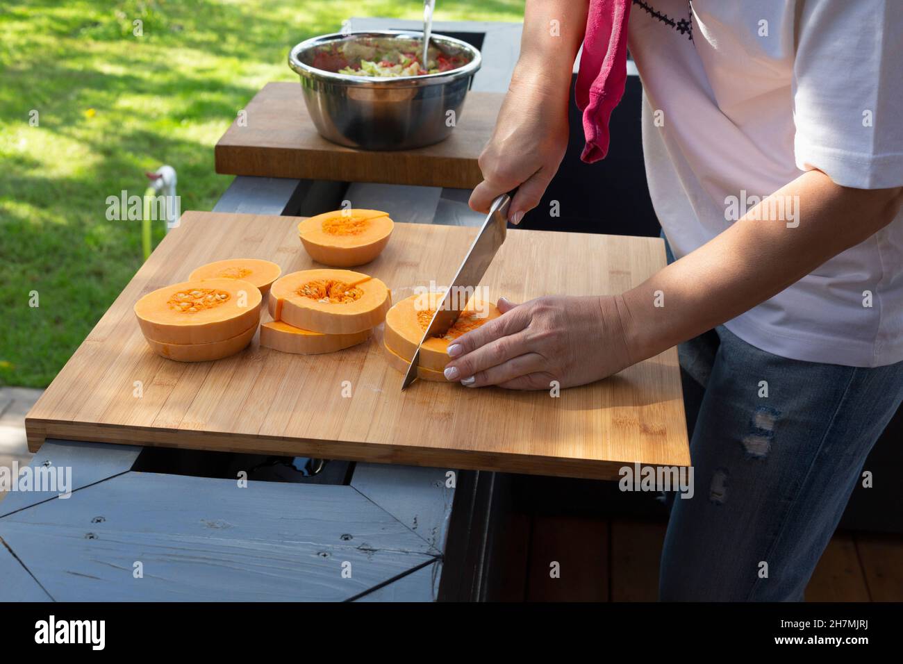 Woman slicing fresh butternut squash on patio Stock Photo - Alamy