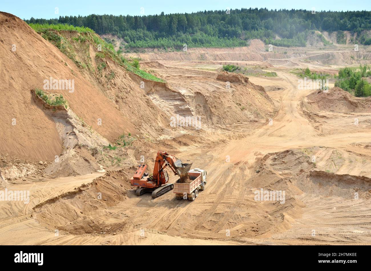 Excavator developing the sand on the opencast and loading it to the ...