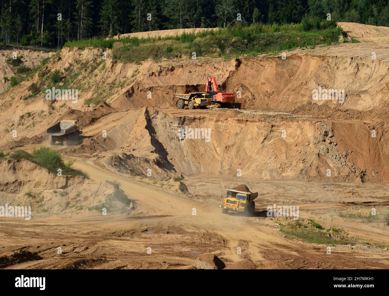 Excavator developing the sand on the opencast and loading it to the ...