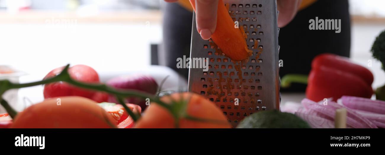 Chef grating carrots to make vegetable salad closeup Stock Photo - Alamy