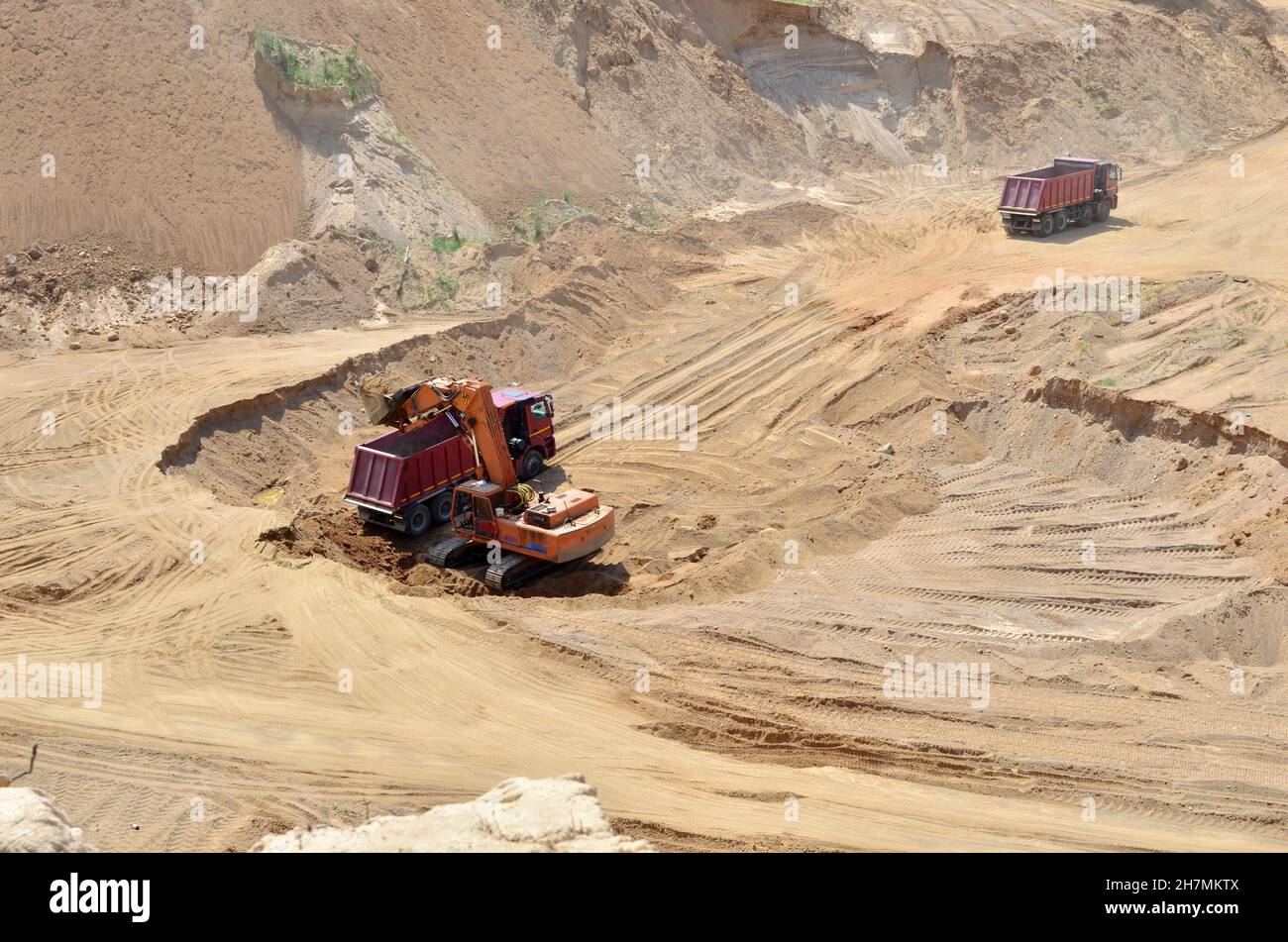 Excavator developing the sand on the opencast and loading it to the ...
