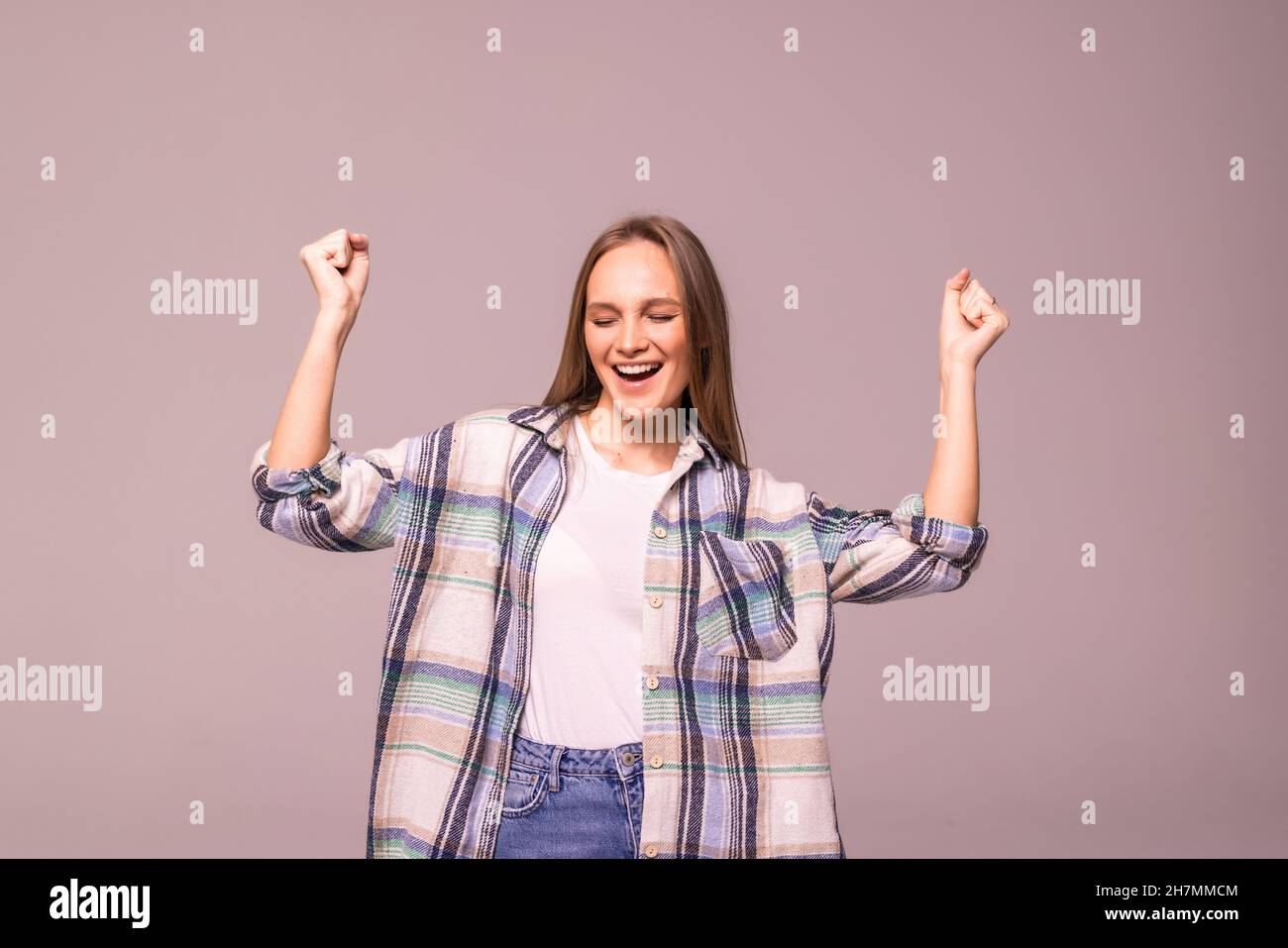 Pretty woman doing a winner gesture happy excited looking up with ...