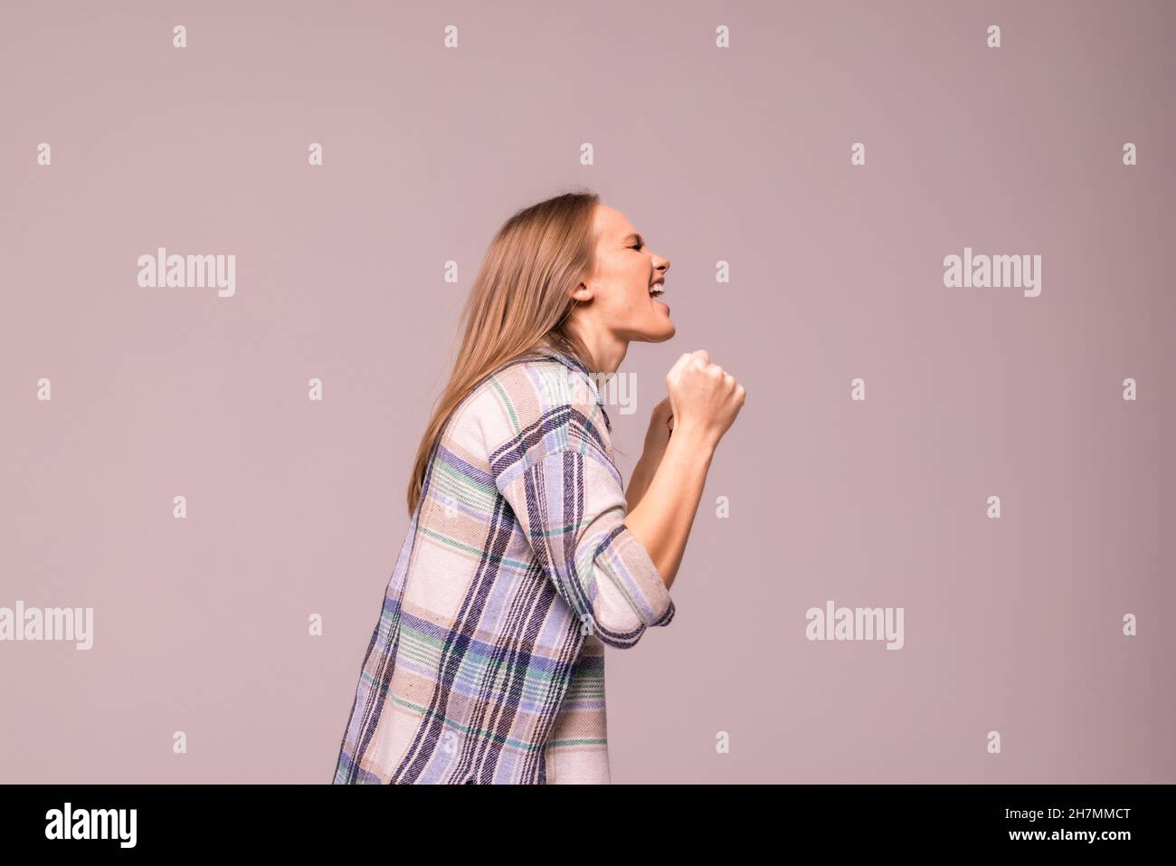 Pretty woman doing a winner gesture happy excited looking up with ...
