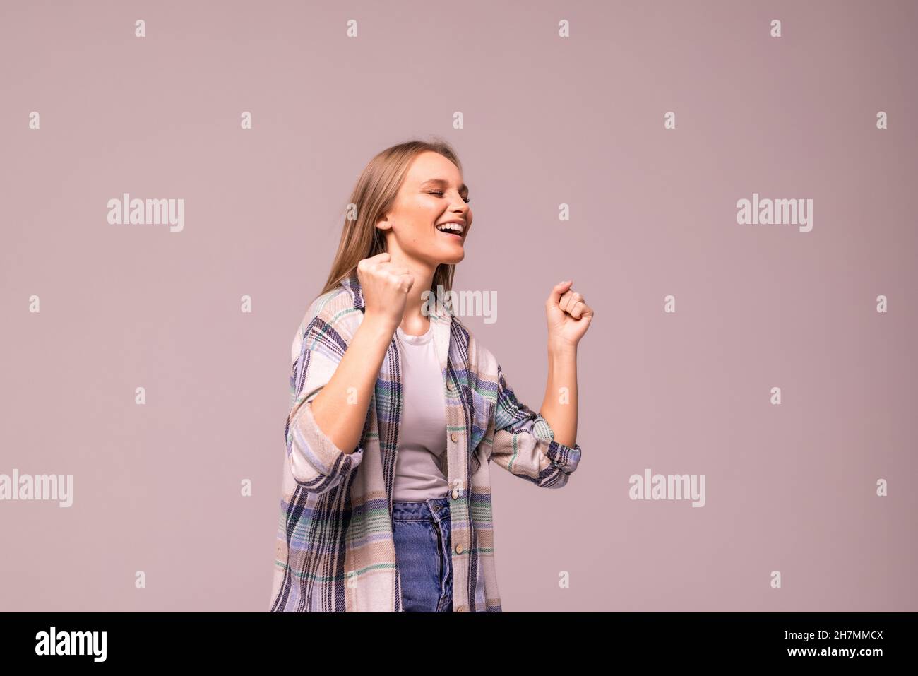 Pretty woman doing a winner gesture happy excited looking up with ...