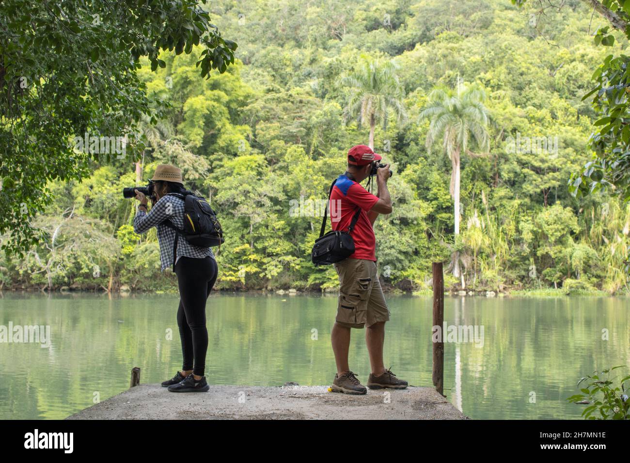 Hispanic tourists taking a picture of a beautiful lake with their ...