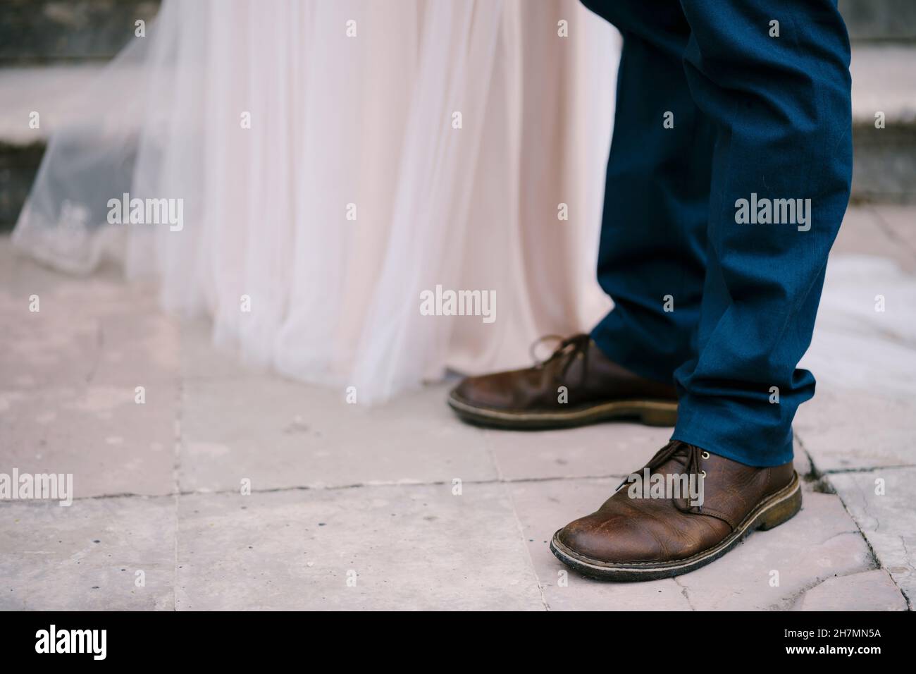 Feet of the bride and groom on a stone tile Stock Photo - Alamy