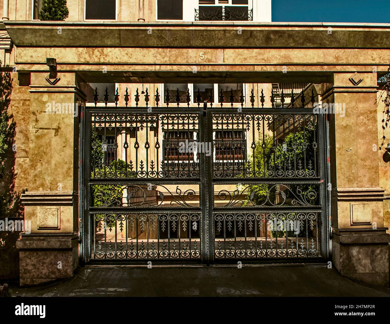 Double-leaf iron gates assembled from strip steel connected by curved ...