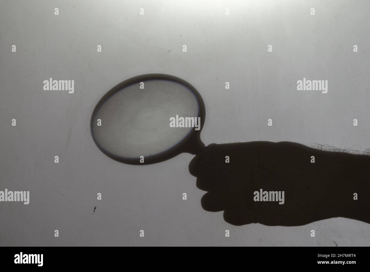 Blur, defocus, noise, grain effect. Dark silhouette of a hand holding a ...