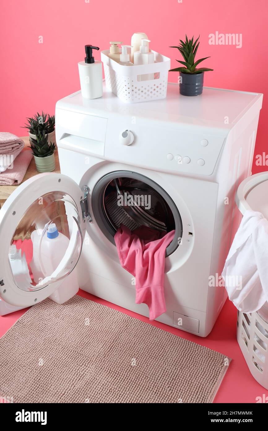 Concept of housework with washing machine on pink background Stock ...