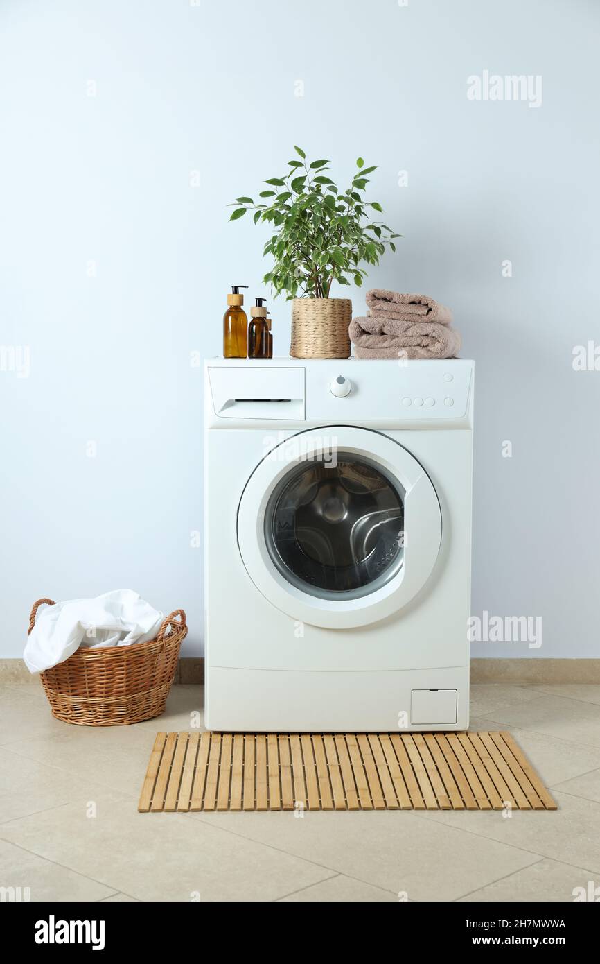 Concept of housework with washing machine against white wall Stock ...
