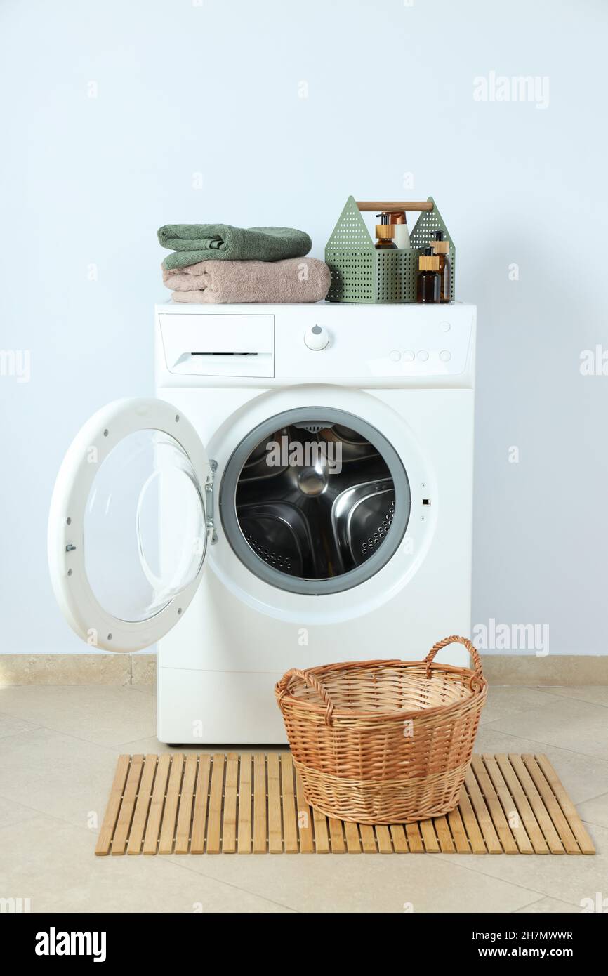 Concept of housework with washing machine against white wall Stock ...