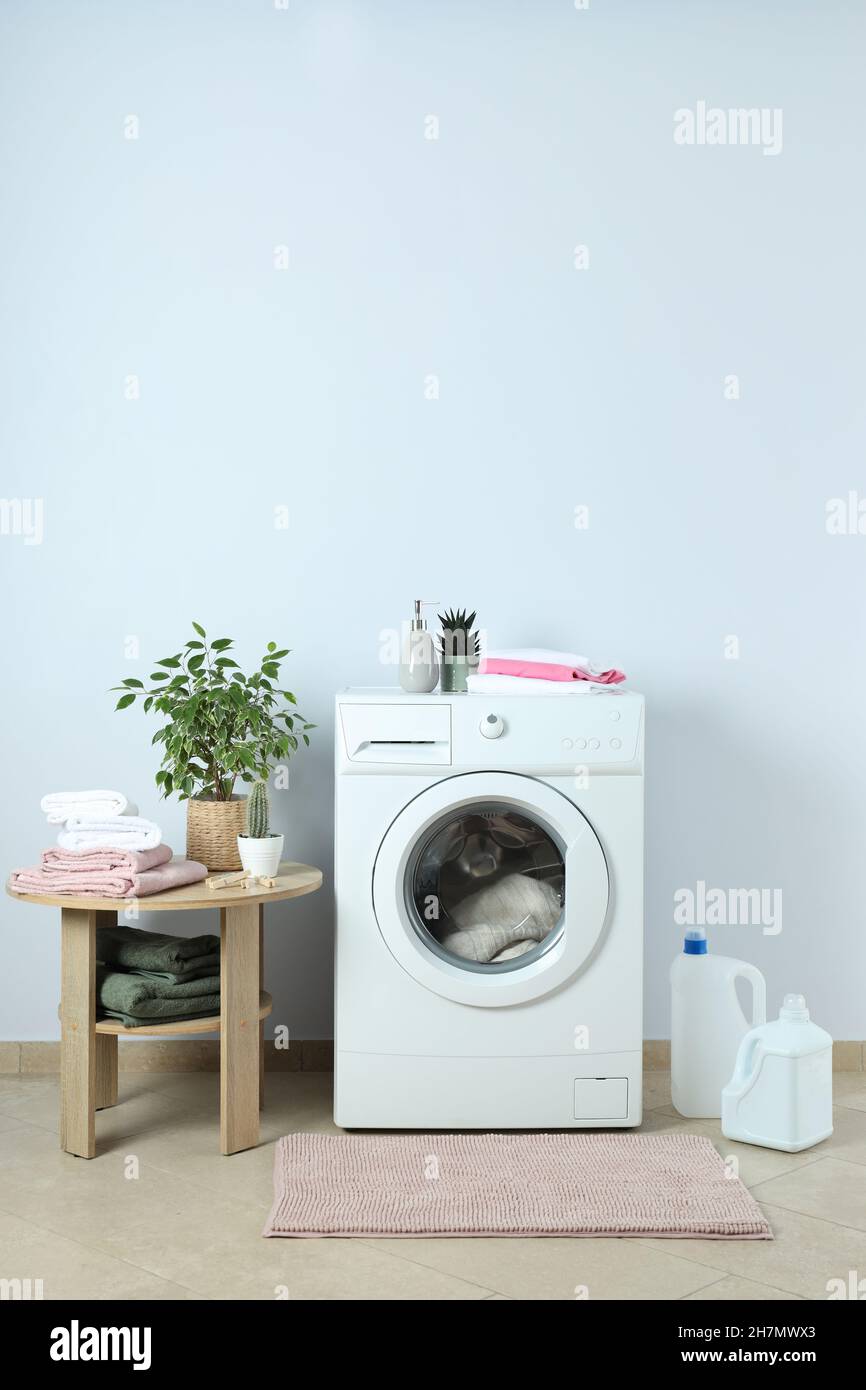 Concept of housework with washing machine against white wall Stock ...
