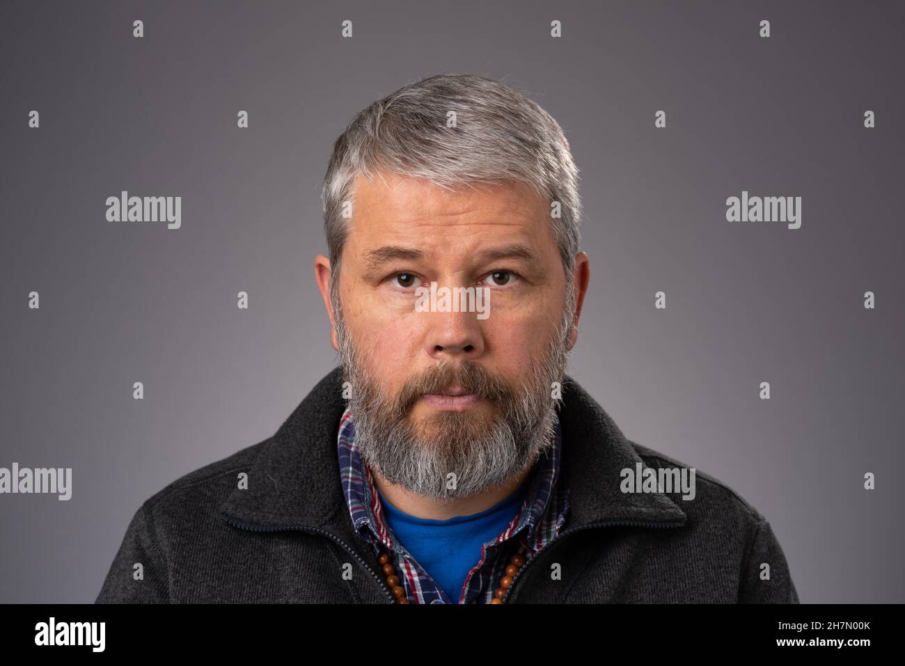 Man with full beard in studio, portrait, 54 years old, rosary around ...