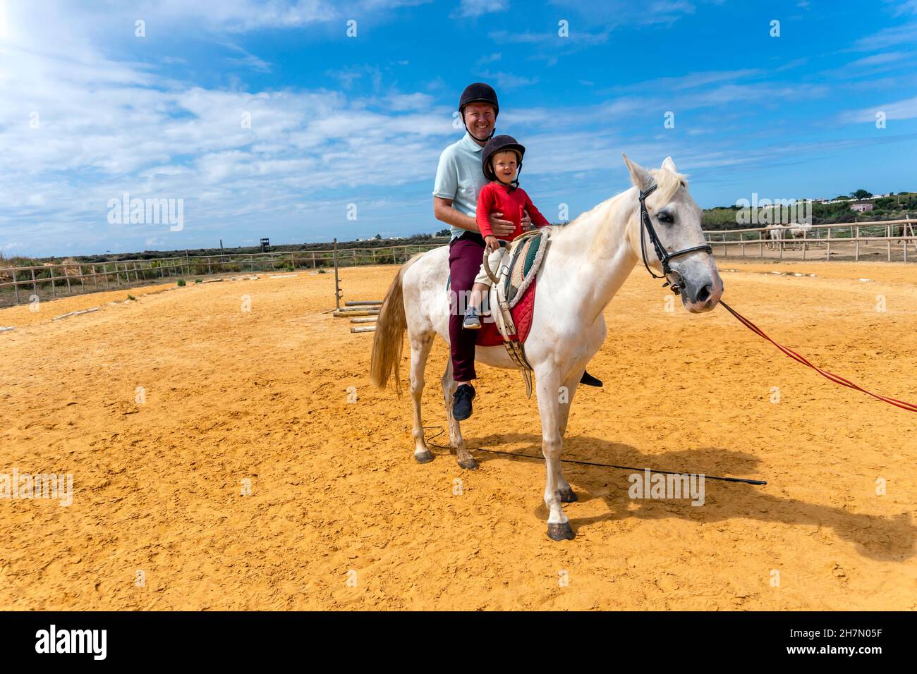 Father and son enjoying horse riding in the paddock Stock Photo - Alamy