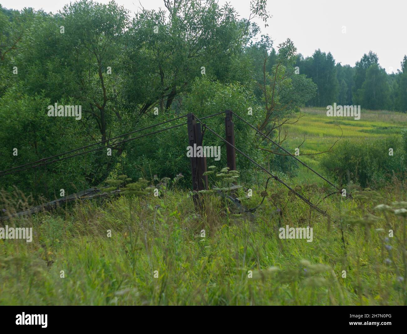 a collapsed wooden pedestrian bridge over the river, in summer Stock ...