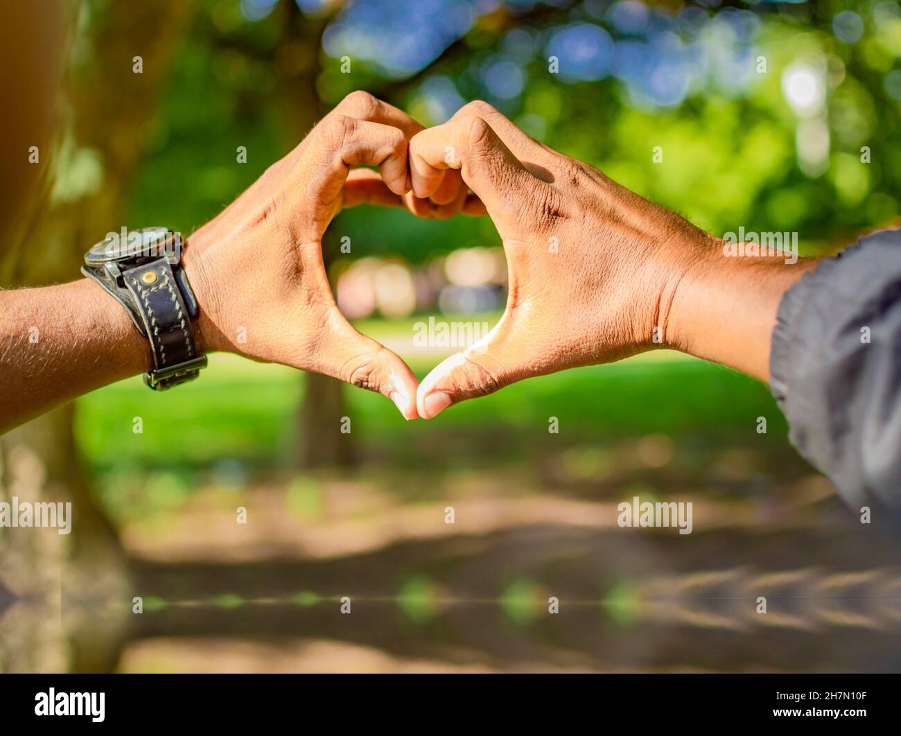 Close up of two hands together in a heart shape, hands together in a ...