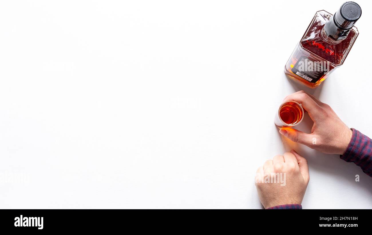 holds a glass of alcohol in his hand, clenches the other hand into a ...