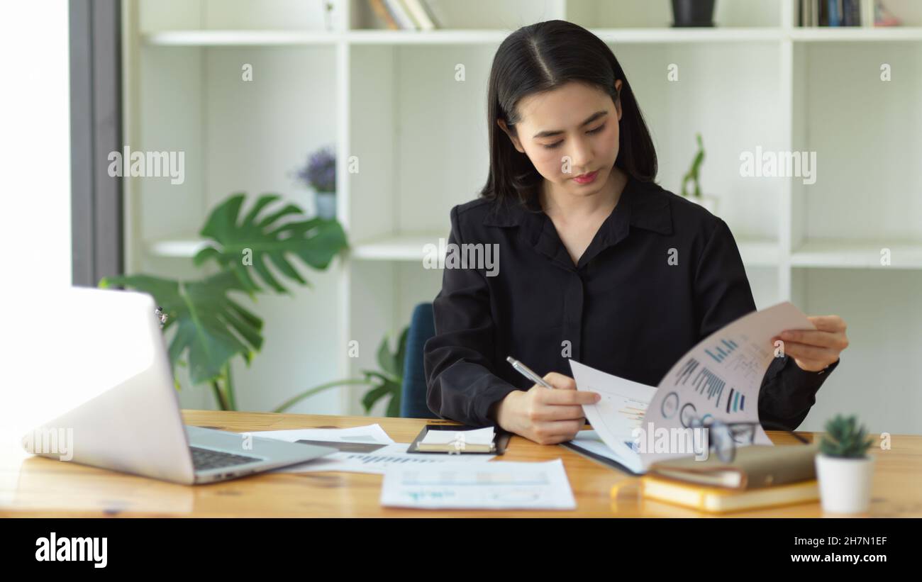 A professional female boss working in her modern office, planning and ...