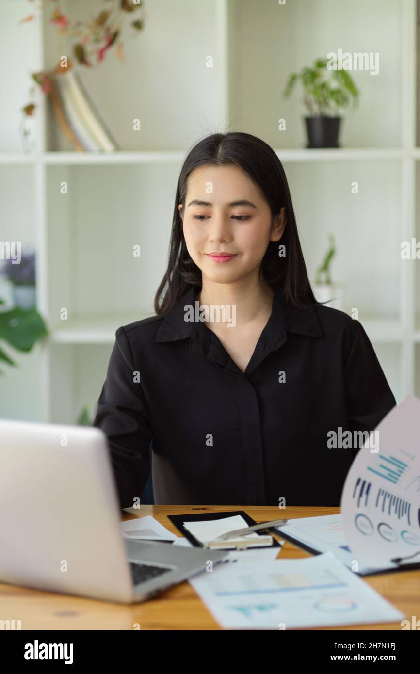 Portrait of a Pleased female financial worker working with company's ...