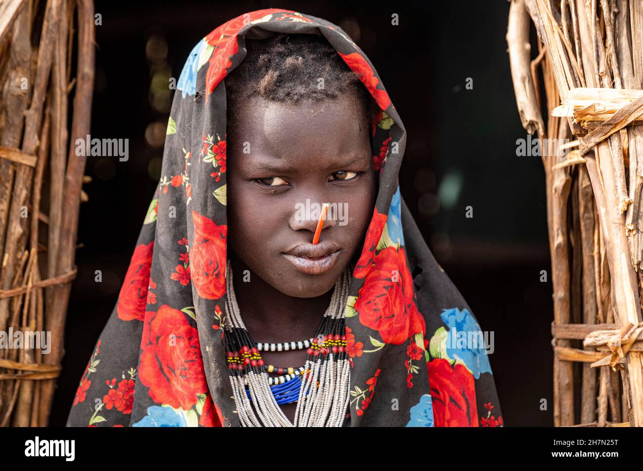 Traditional dressed child of the Jiye tribe sitting in her hut, Eastern ...