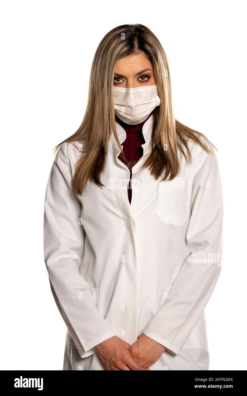 Young unhappy female doctor with face medical mask on a white ...