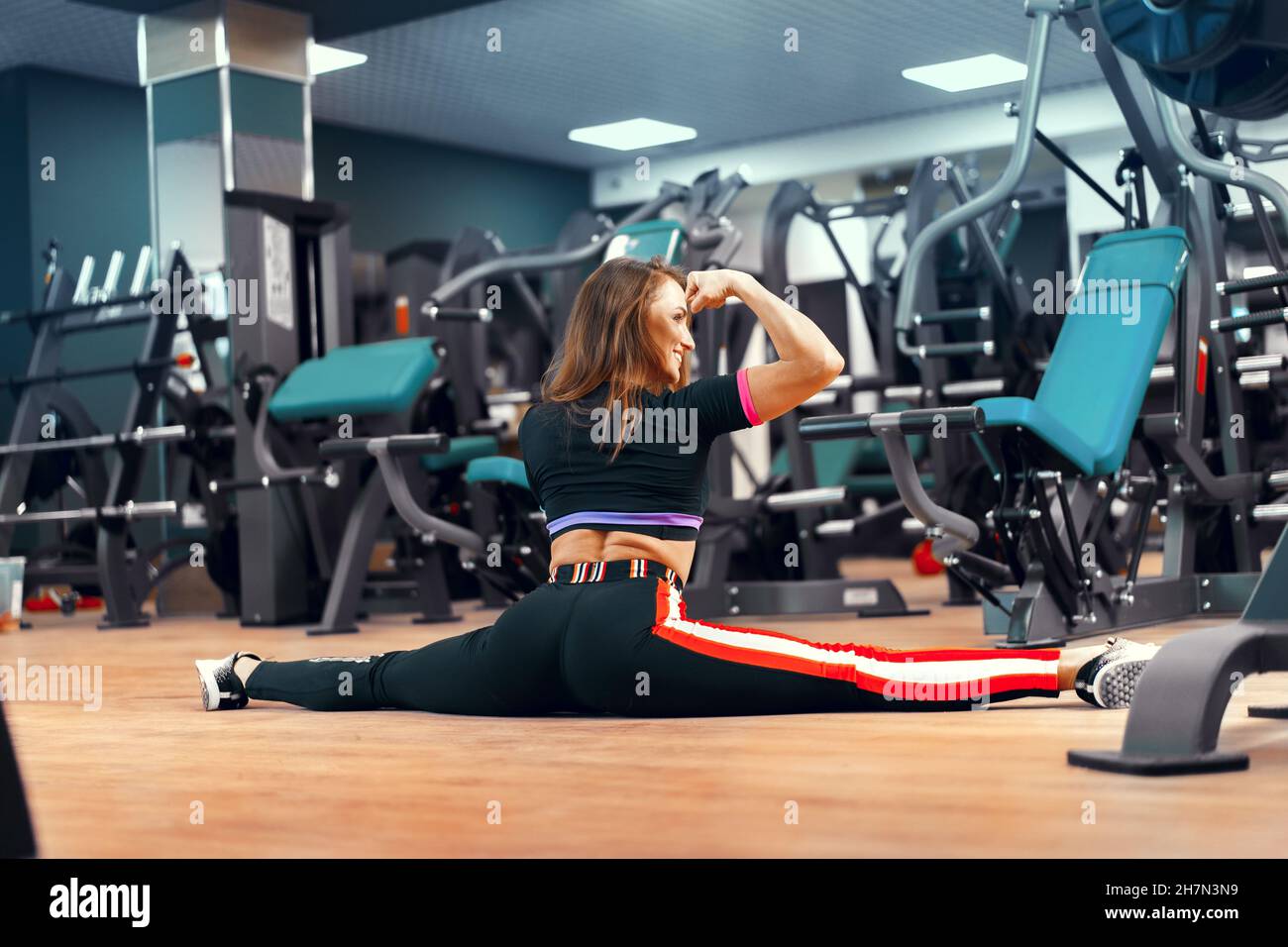 Beautiful girl fitness trainer stretching her body after workout Stock ...