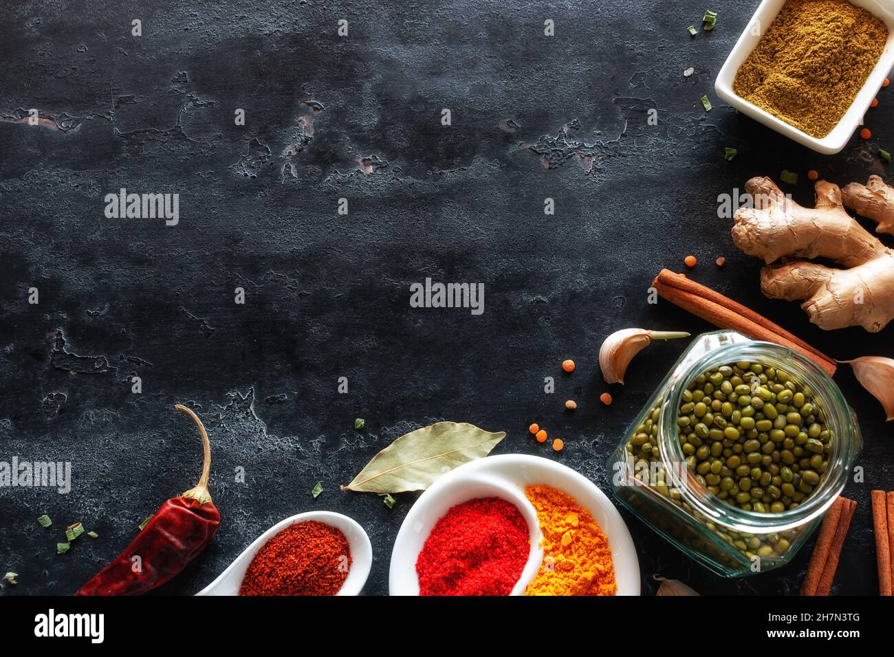 spices herbs and condiments on black kitchen table with place for text ...