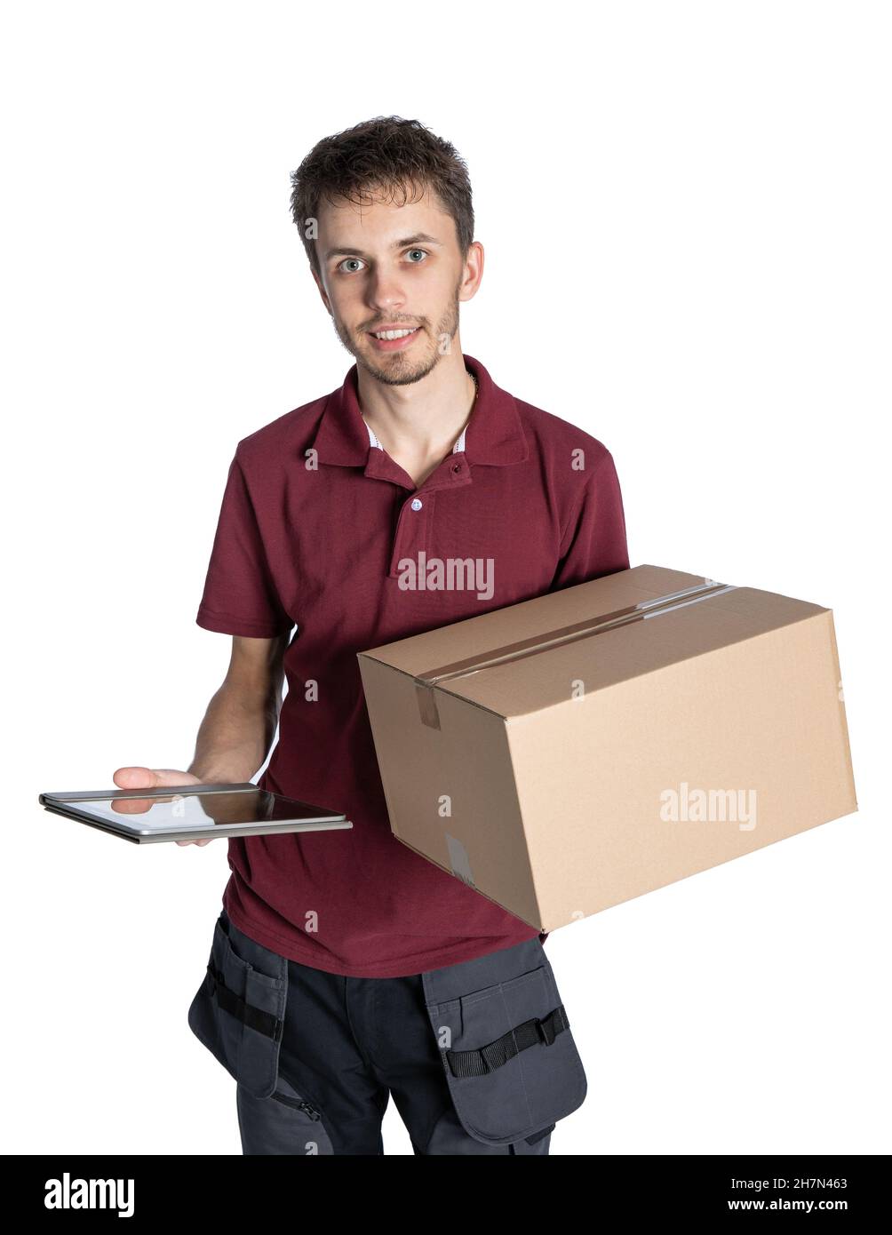 Smiling delivery man holding pile of cardboard boxes on a white ...