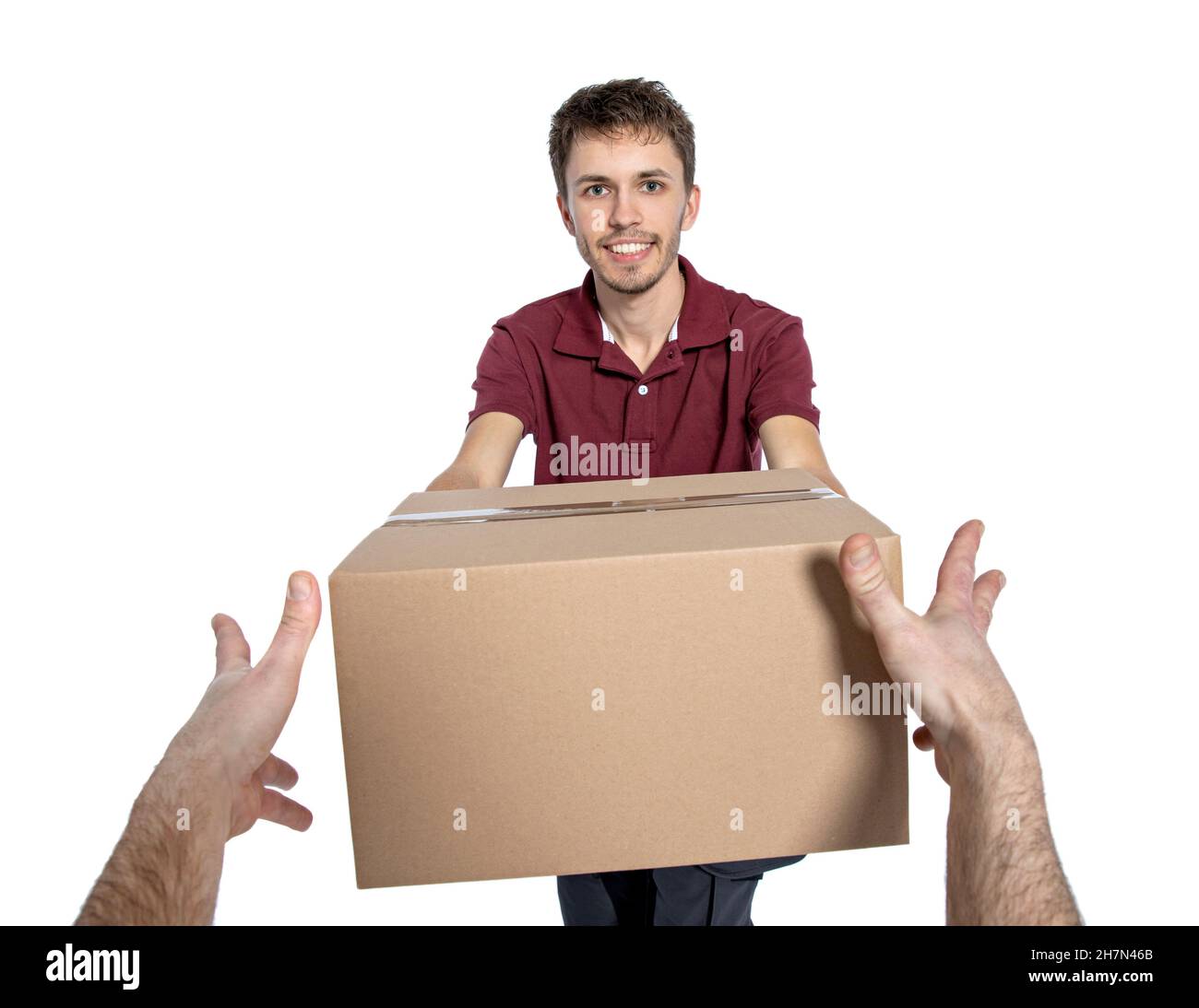 Smiling delivery man holding pile of cardboard boxes on a white ...