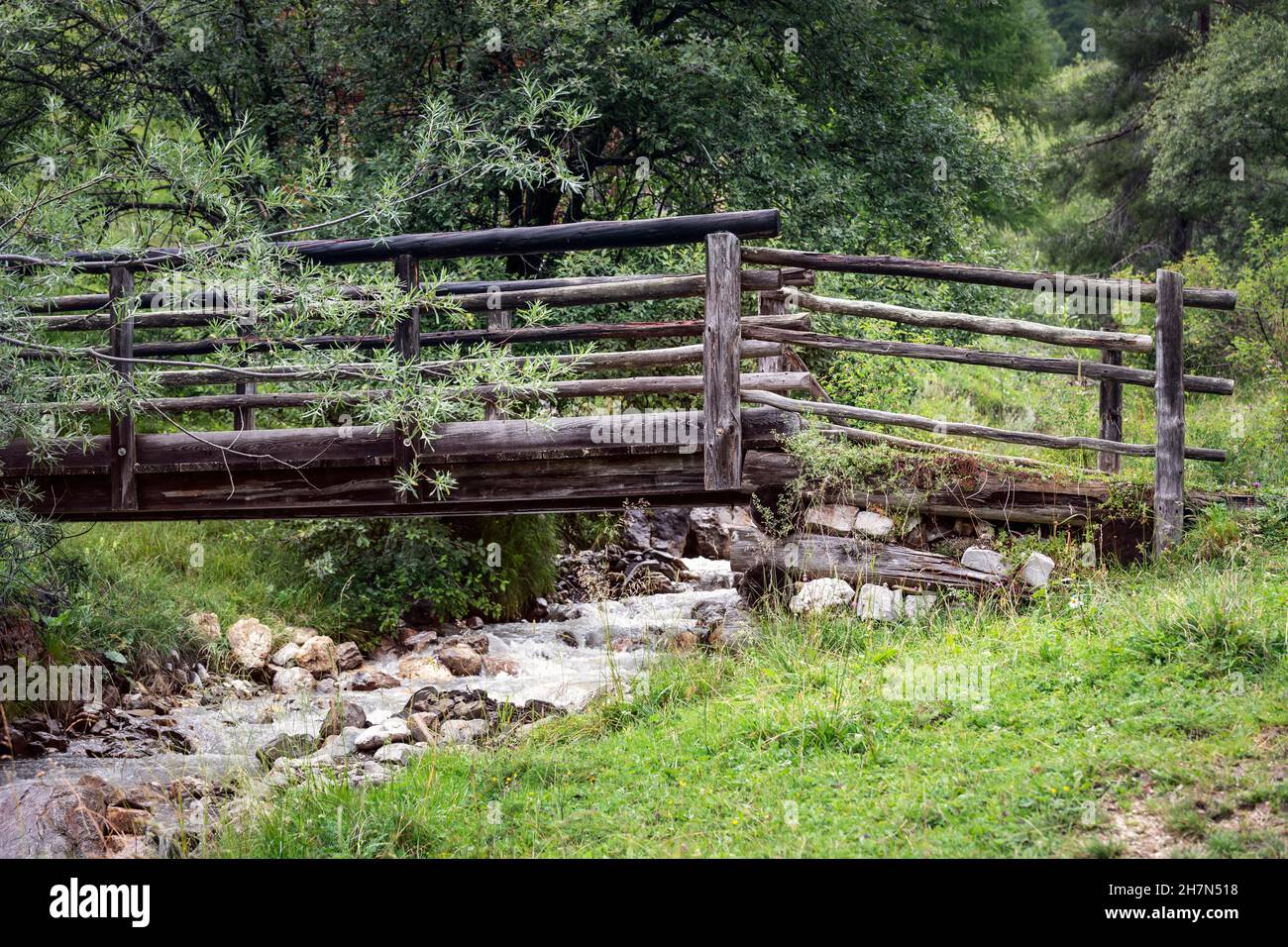 Old wooden footbridge over a stream in the Alps Stock Photo - Alamy