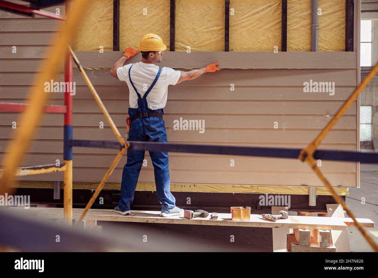 Male worker building cabin at construction site Stock Photo - Alamy