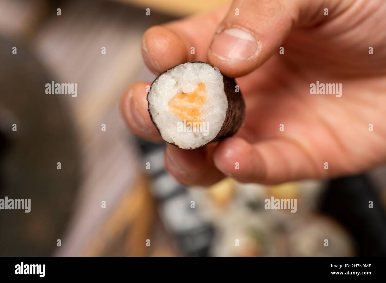 Young man's hand ready to approach his mouth a piece of Norwegian ...