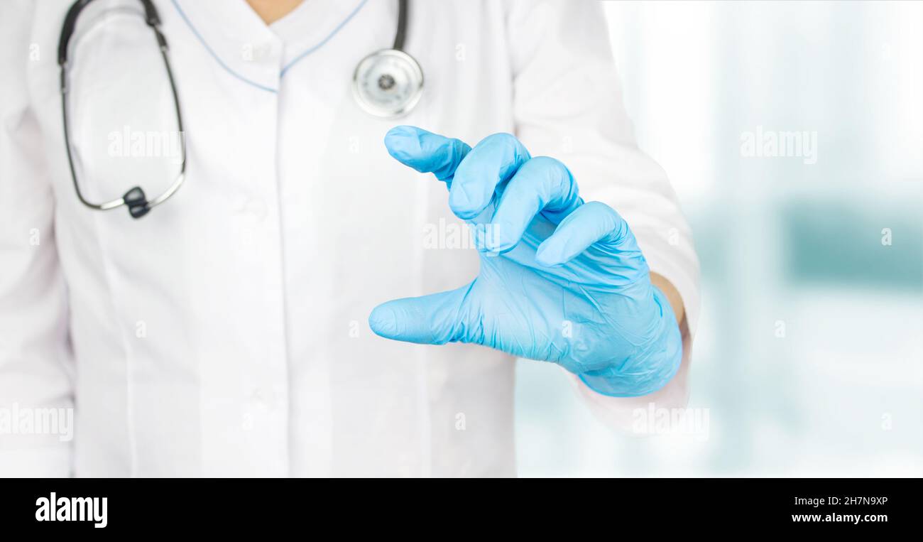 Female doctor showing something in her hand in medical gloves. Doctor ...