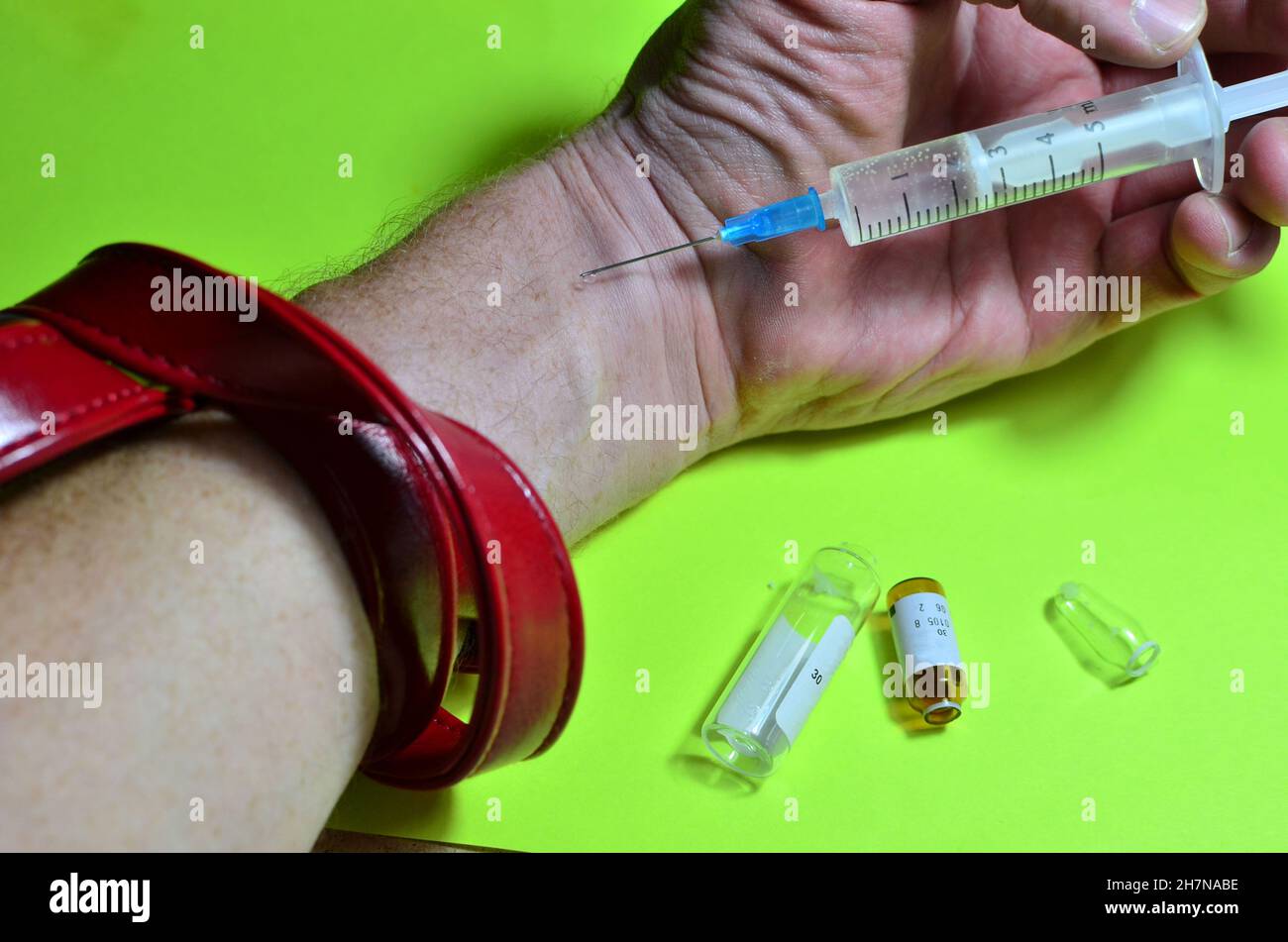 A drug addict injects a narcotic injection or dose into his hand with a ...