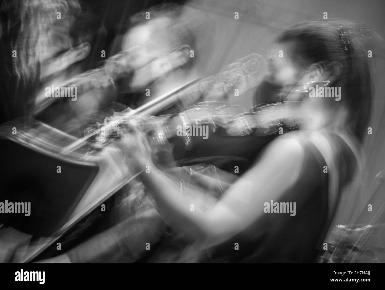 A lady in an orchestra plays a violin wearing a Covid mask during a ...