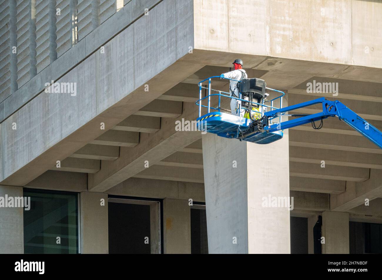 Construction worker working at height using a crane to access aerial ...