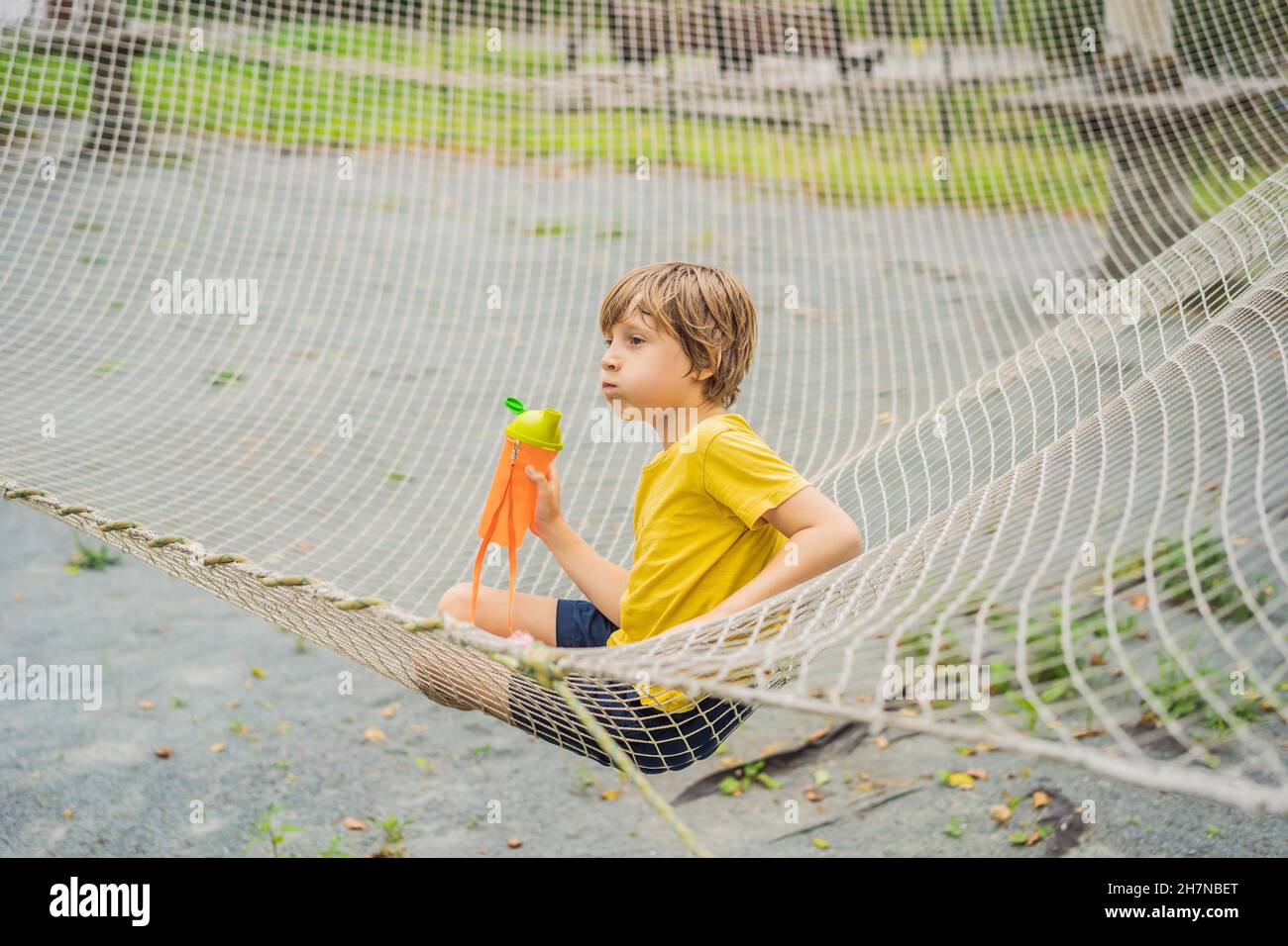 practice nets playground. boy plays in the playground shielded with a ...