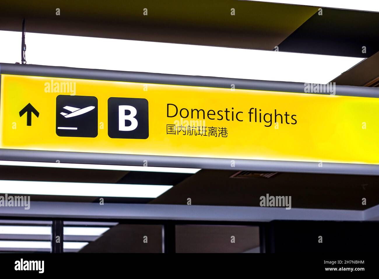 Bright illuminated yellow and black airport signs with arrows and plane ...